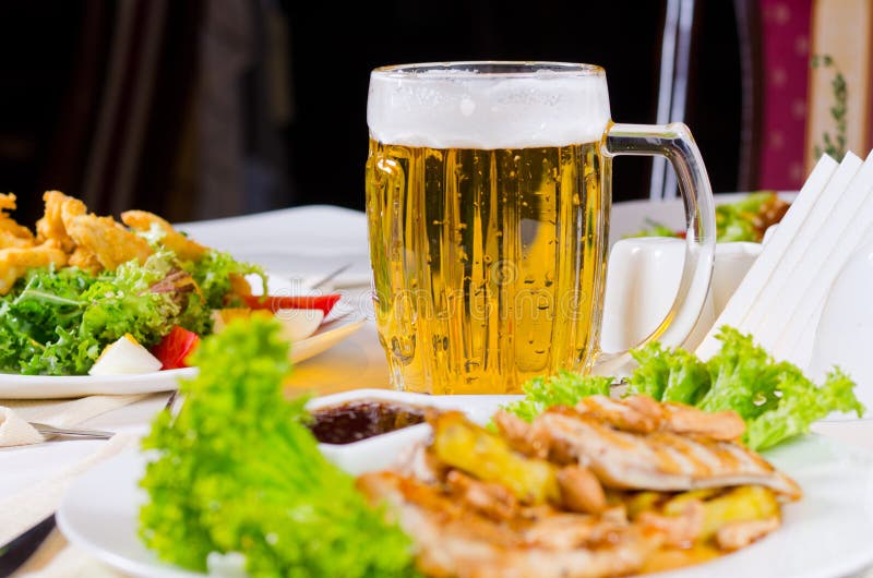 Mug of Beer on Table with Plated Food Dishes Stock Image - Image of ...