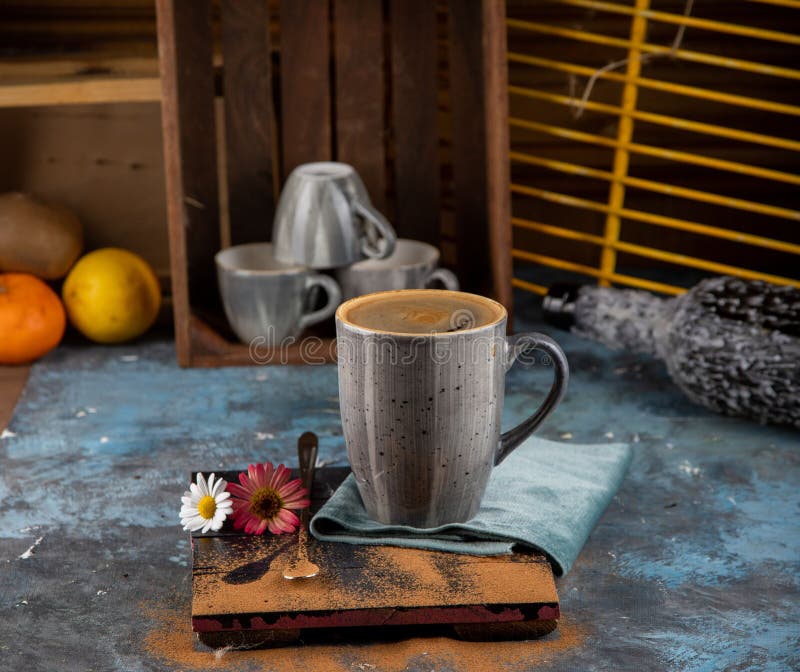 Mug of a Coffee Latte on a Fabric Surface Alongside Flowers on a Wooden ...