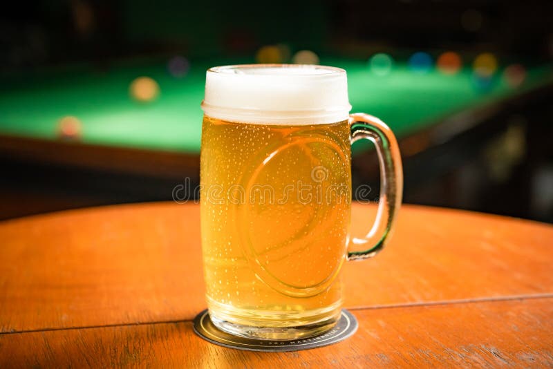 Mug with Draft Beer on a Table with Pool Table Behind. Stock Image ...