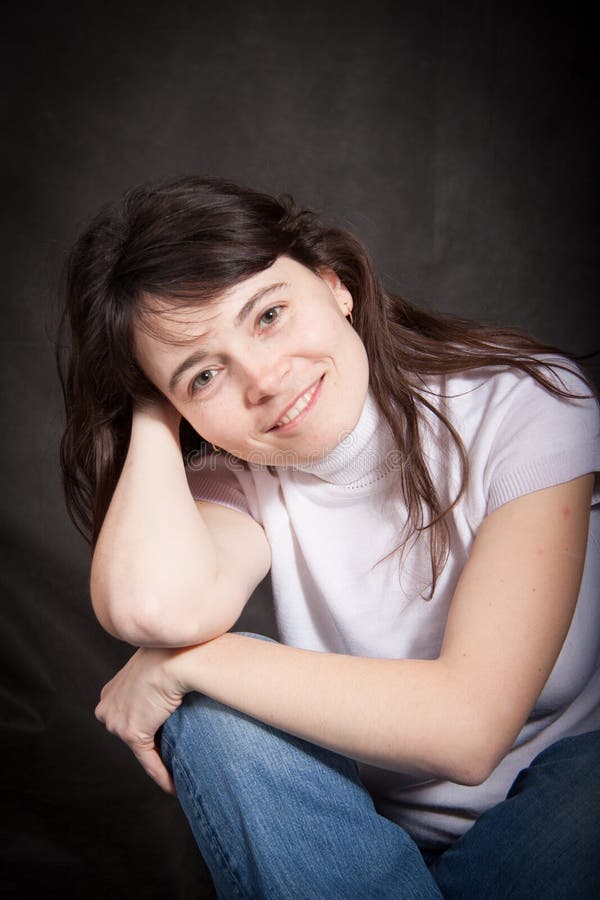 Mujer En Los Vaqueros Que Se Sientan En El Piso Foto de archivo ...