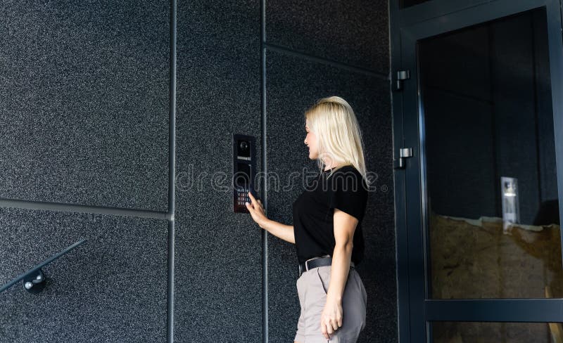 Mujer Feliz Llamando a Timbre En La Entrada Del Edificio. Usar Intercom ... Mujer Feliz Llamando a Timbre En La Entrada Del Edificio. Usar Intercom ...