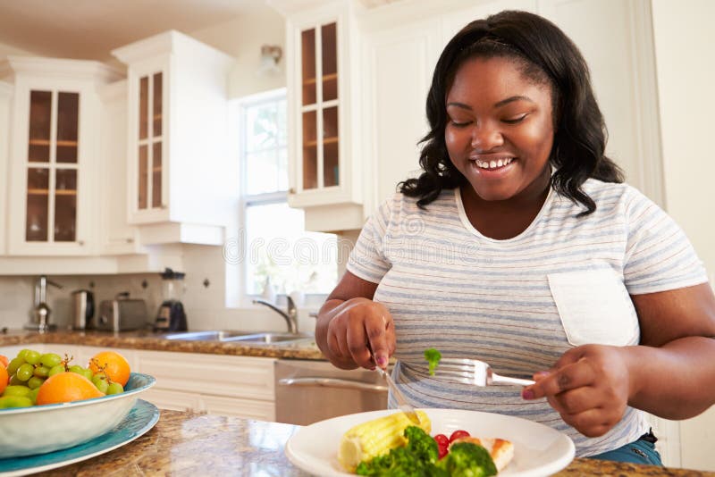 Mujer Gorda Que Come La Comida Sana En Cocina Imagen de archivo ...
