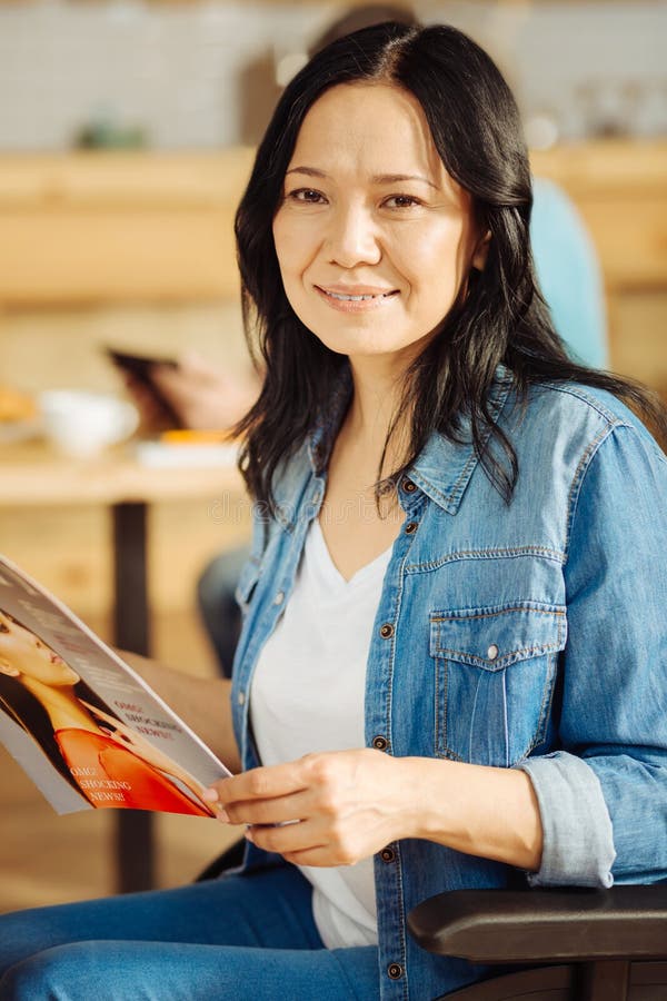 Mujer Lisiada Sonriente Que Sostiene Una Revista Imagen de archivo ...