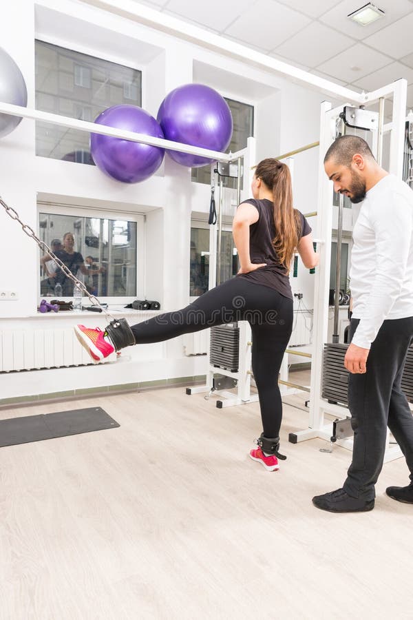 Mujer Que Ejercita Las Piernas Con Ayuda Personal Del Instructor Imagen ...