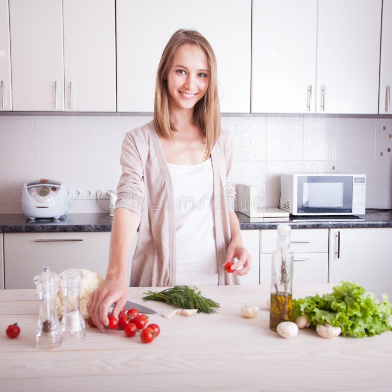 Mujer Sonriente Que Hace La Comida Sana En Cocina Foto de archivo ...