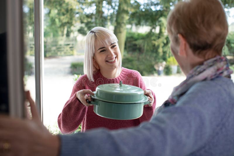 Mujer Que Trae La Comida Para El Vecino Mayor Imagen de archivo ...