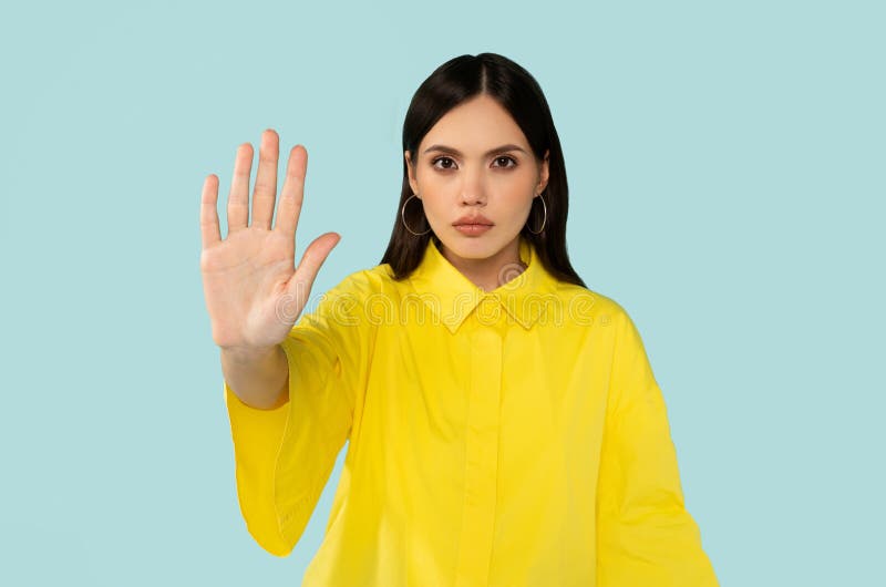Mujer Seria Y Joven Latino Casual Parada Con La Mano Extendida