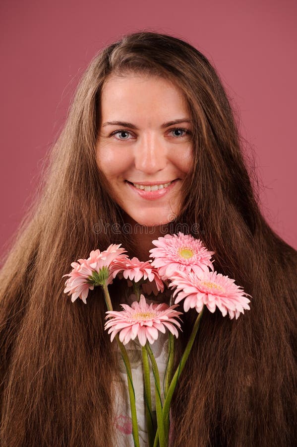 Mujer Sonriente Con Flores Rosas. Fondo Rosa Studio Imagen de archivo ...