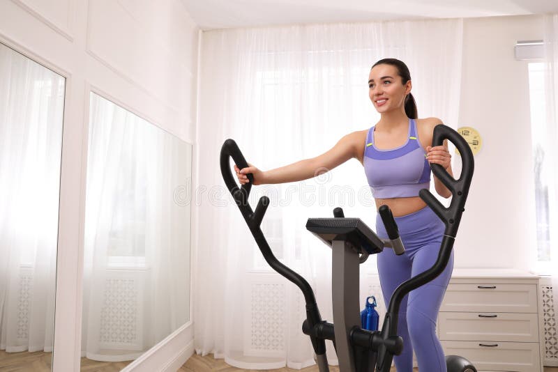Mujer Con Máquina Elíptica Moderna En Casa Foto de archivo - Imagen de aptitud, bici: 212047268