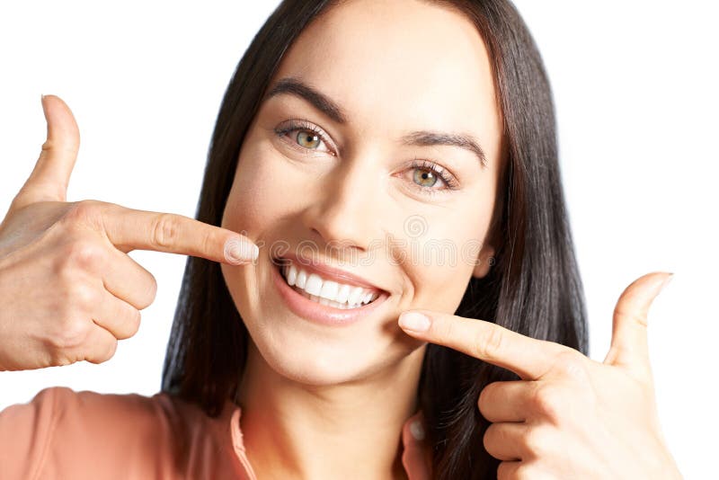 Mulher Atrativa Que Aponta A Seu Sorriso Com Os Dentes Brancos