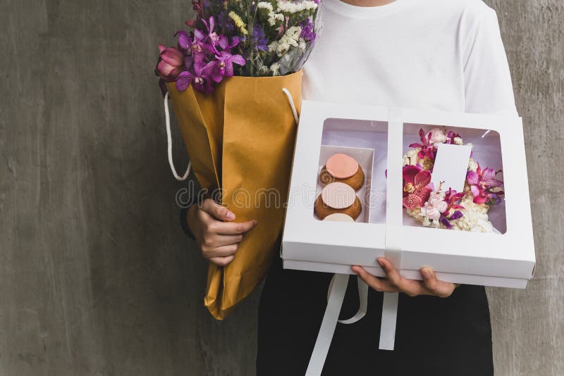Mulher Que Guarda Flores E Caixa De Presente No Fundo Cinzento Foto de ...