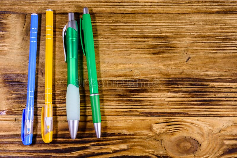 Multi Colored Ball Pens on a Wooden Table. Top View Stock Photo - Image ...