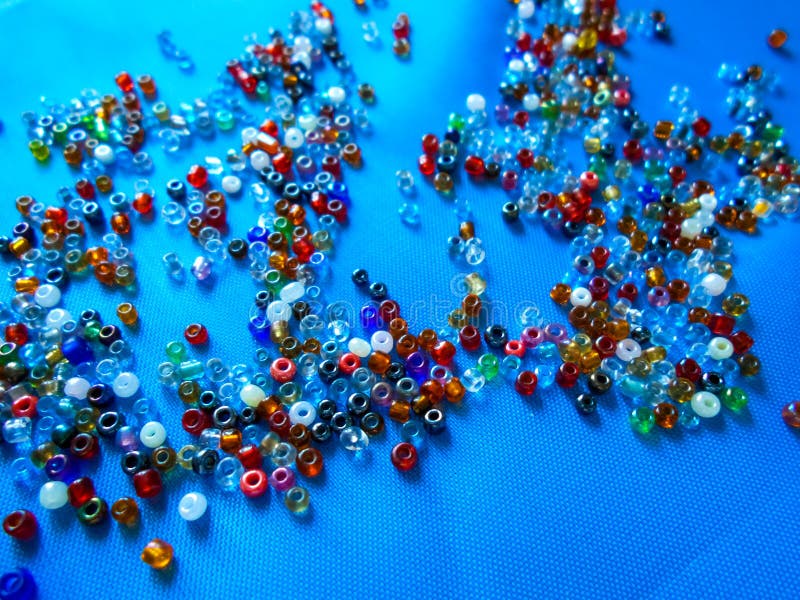 Multi-colored Beads on a Blue Fabric Stock Photo - Image of white ...