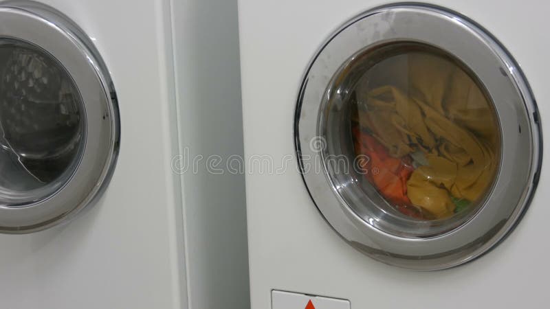 Multi-colored Clothes Laundry is Washed in a White Washing Machine in ...
