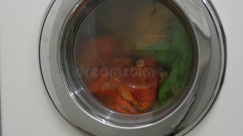 Multi-colored Clothes Laundry is Washed in a White Washing Machine in ...