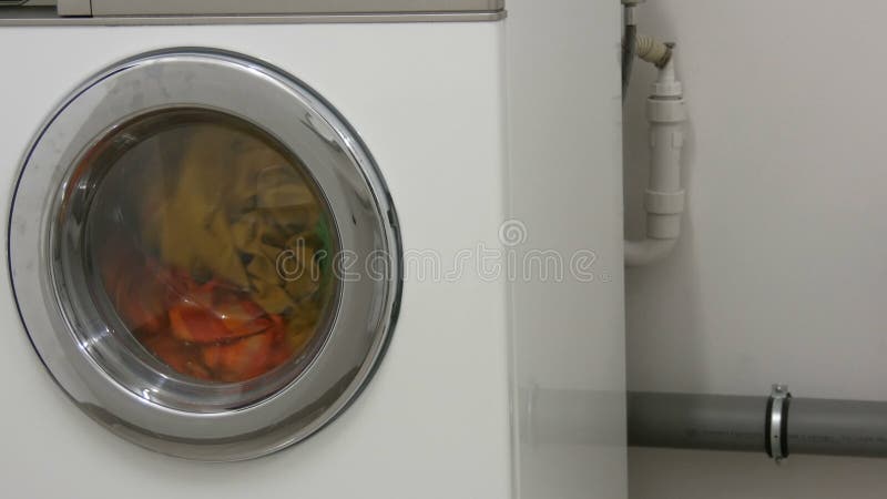 Multi-colored Clothes Laundry is Washed in a White Washing Machine in ...