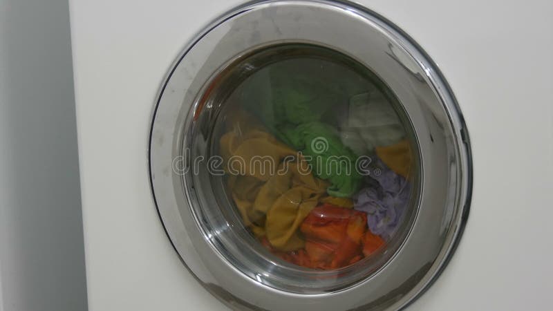 Multi-colored Clothes Laundry is Washed in a White Washing Machine in ...