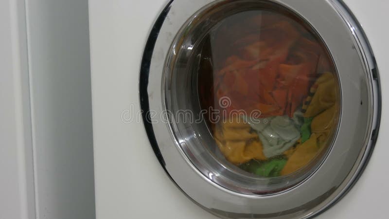 Multi-colored Clothes Laundry is Washed in a White Washing Machine in ...