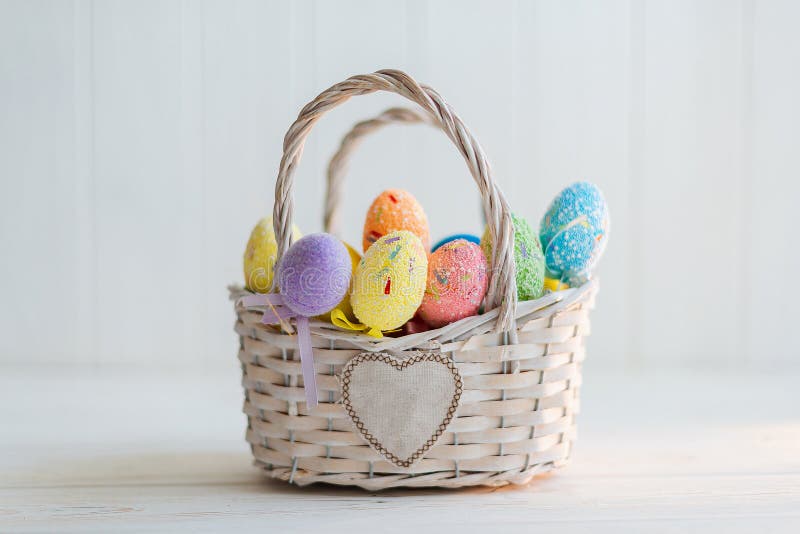 Multi-colored Easter Eggs in a Basket on a White Wooden Background ...
