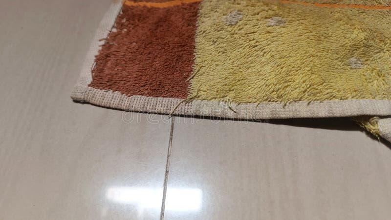 Multi-Colored Fabric Mat Lying on Tile Floor Stock Photo - Image of ...