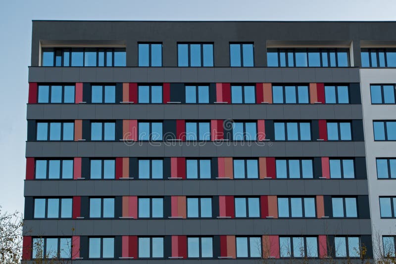 Multi-colored Facade of Building with Rows of Rectangular Blue Windows ...