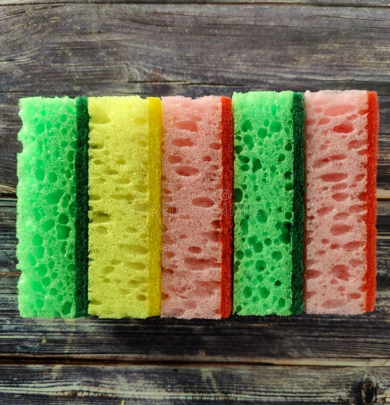 Multi-colored Kitchen Sponges for Washing Dishes on a Wooden Table ...