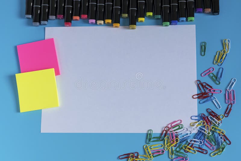 Multi-colored Markers, Paper Clips, Stickers and Paper on a Blue ...