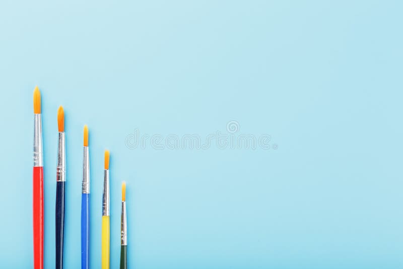 Multi-colored Paint Brushes on a Blue Background Stock Image - Image of ...