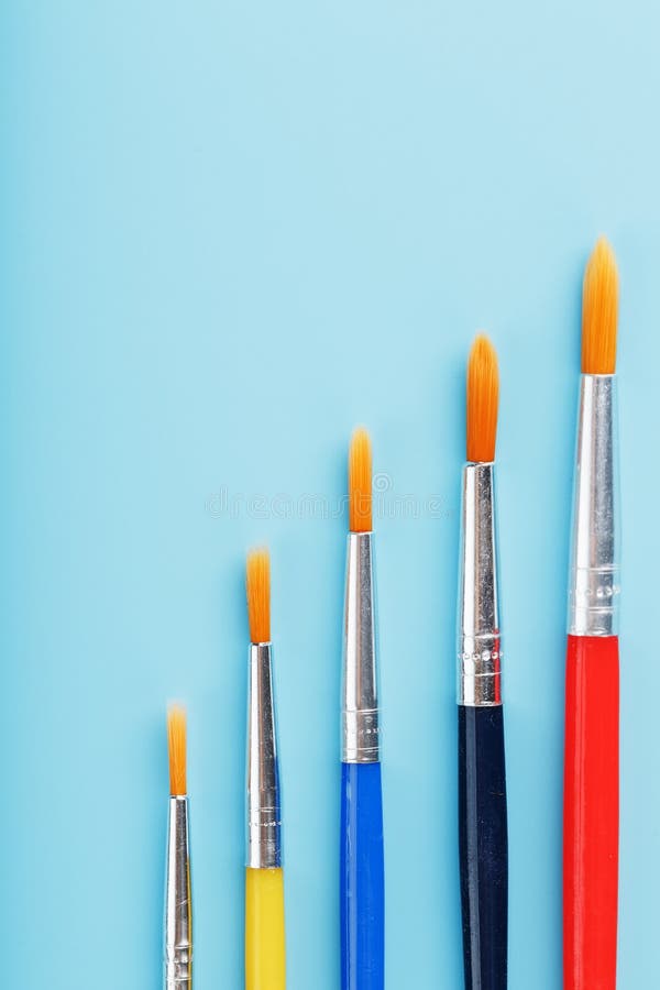Multi-colored Paint Brushes on a Blue Background Stock Image - Image of ...