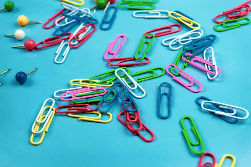 Multi-colored Paper Clips Lie on a Blue Table Stock Photo - Image of ...