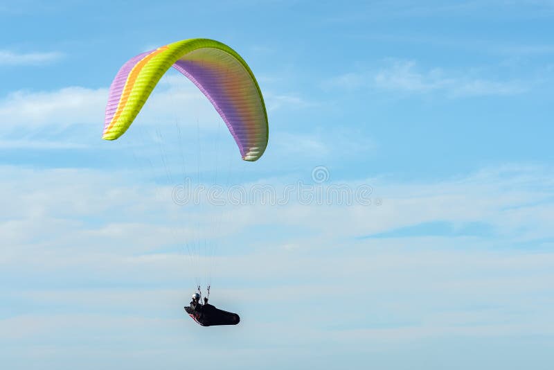 Multi Colored Paraglider Flying in the Sky on a Beautiful Blue Sky with ...