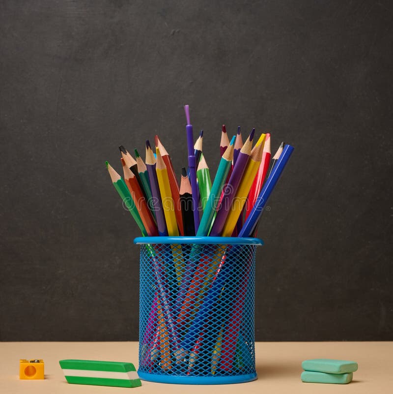 Multi-colored Pencils in a Blue Metal Cup, Sharpener and Erasers ...