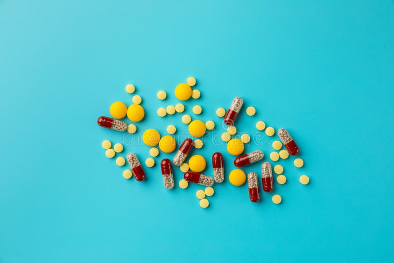 Multi-colored Drugs and Pills on a Blue Background. Plastic White ...