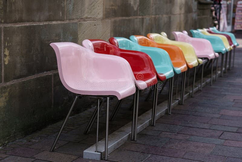 ..Multi-colored Plastic Seats in a Row Against a Gray Wall Stock Photo ...