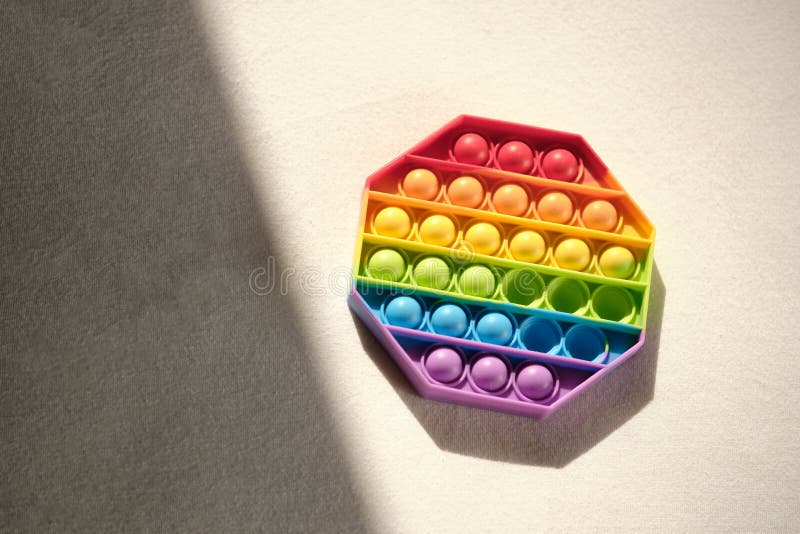 Multi-colored Plastic Toy Pop it Lies on the Bed in Bright Sunlight ...