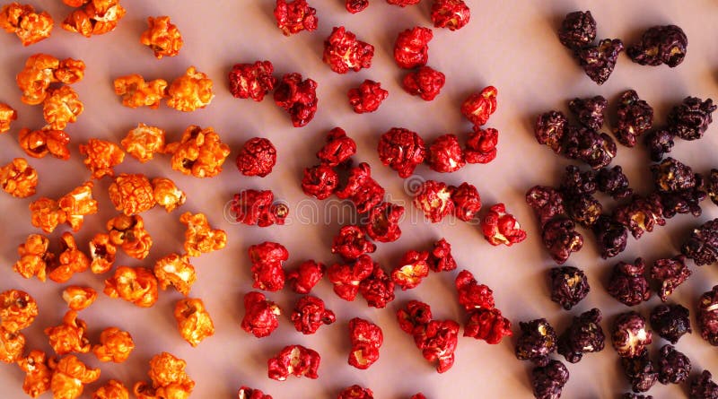Multi-colored Popcorn in Caramel Glaze Scattered in Rows on a Pink ...