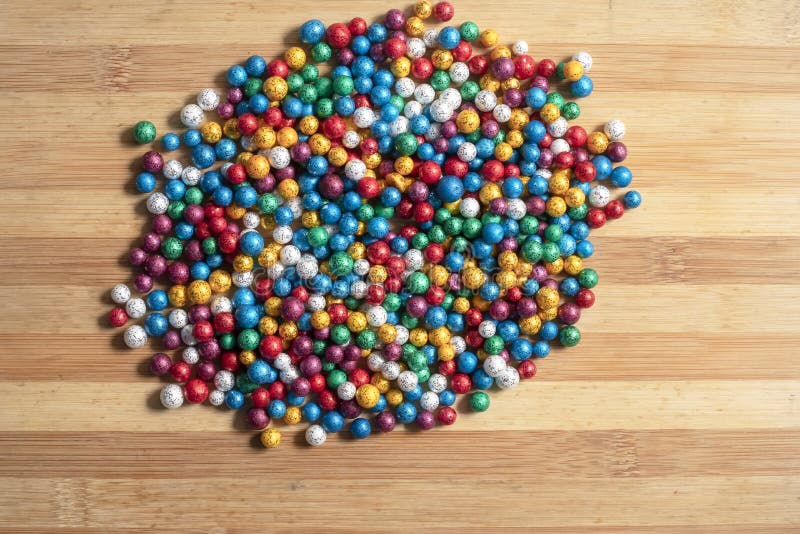 Multi-colored Small Thermocol Decorative Balls on a Wooden Table Stock ...