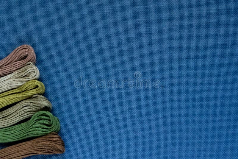 Multi-colored Threads for Embroidery on Blue Canvas. Place for Text ...