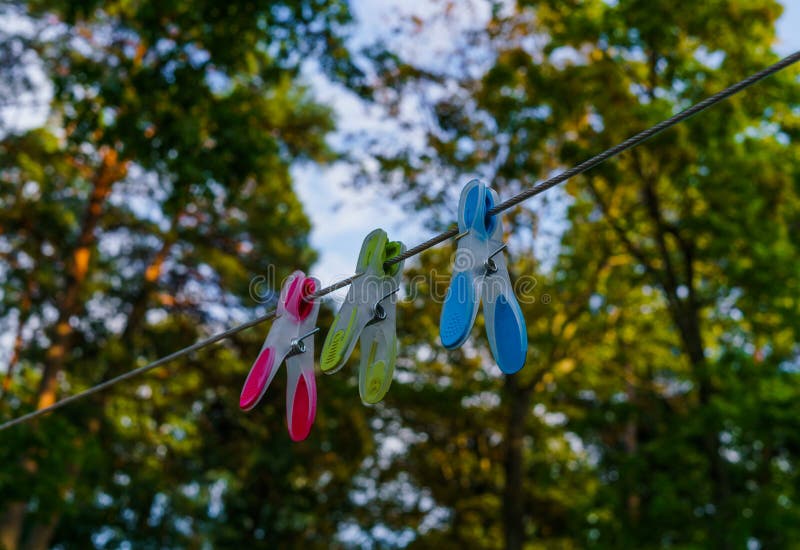 Multi-colored Three Clothes Pegs Attached To a Long Rope in the ...
