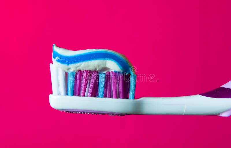 A Multi-colored Toothpaste is Applied To a Multi-colored Toothbrush ...