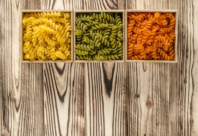 Multi-coloured Pasta in the Form of Spirals Lies in Square Wooden Boxes ...