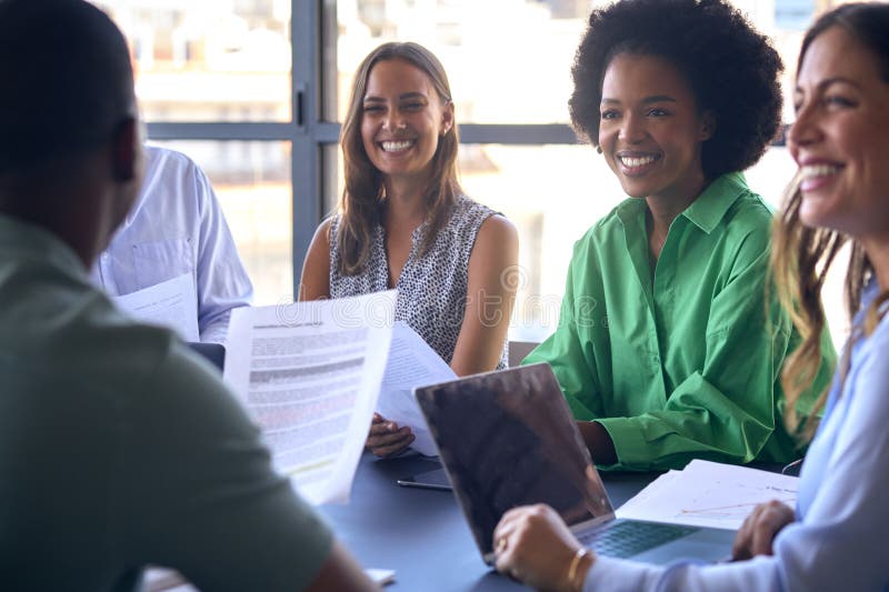 Multi-Cultural Business Team Meeting Around Office Boardroom Table with ...
