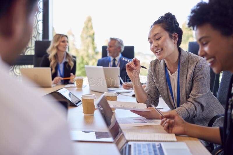 Multi-Cultural Business Team Meeting and Collaborating Around Table in ... Multi-Cultural Business Team Meeting and Collaborating Around Table in ...