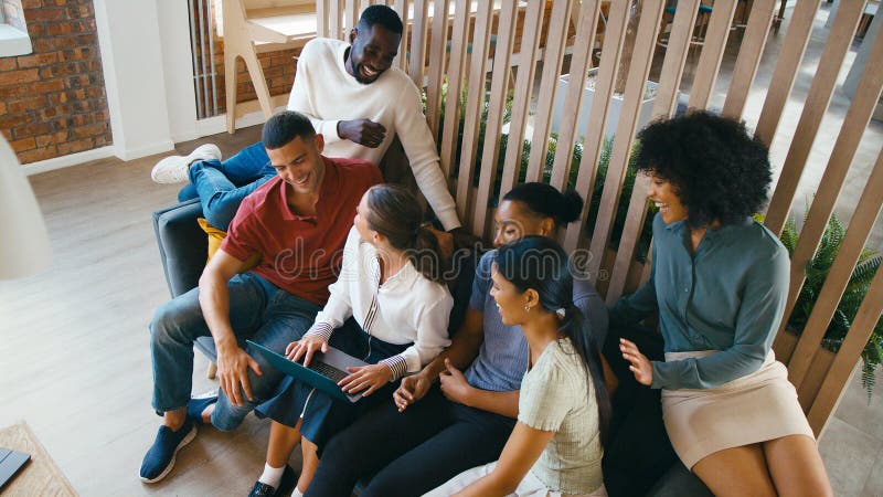 Multi-Cultural Business Team Sitting on Couch in Modern Open Plan ...