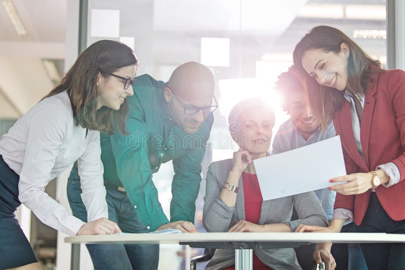 Multi-ethnic Business People Discussing Over Document at Table in ...