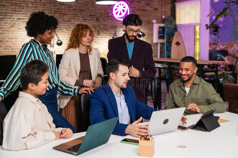 Multi Ethnic Team Collaborating on Project Using Laptop in Modern ...