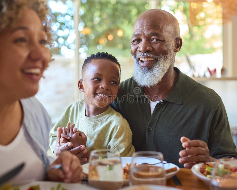Multi-Generation Family Around Table Serving and Eating Meal at Home ...