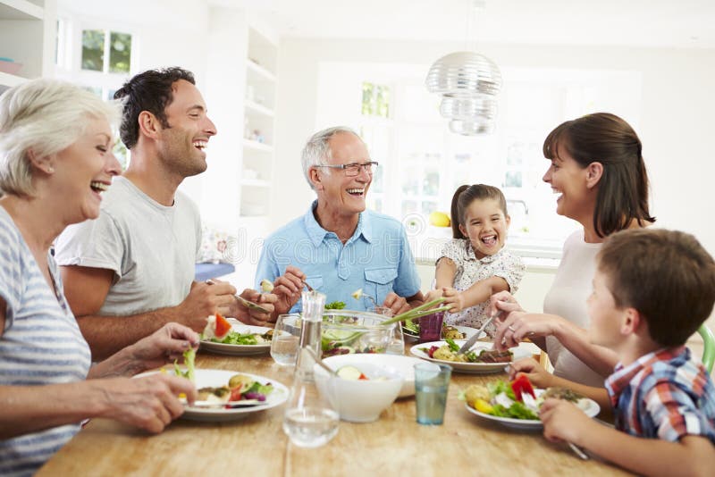 Multi Generation Family Eating Meal Around Kitchen Table Stock Photo ...