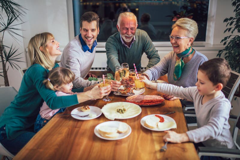 Multi Generation Family Enjoying Meal Around Table Stock Photo - Image ...
