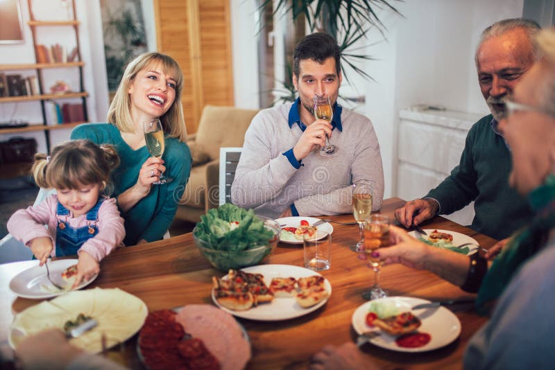 Multi Generation Family Enjoying Meal Around Table Stock Image - Image ...